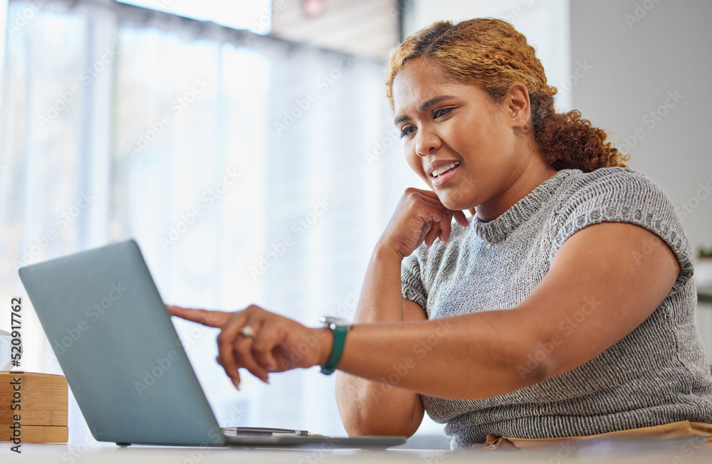 Confused businesswoman reading an email on a laptop indoors. One young ...