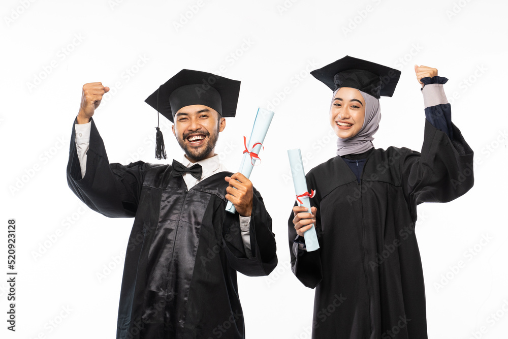 Excited graduate wearing toga holding a roll of diploma paper during ...