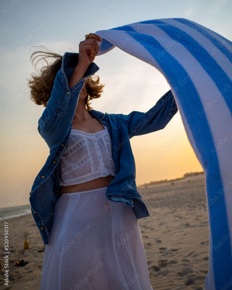 Hip millennial woman in see through dress and bikini beating sand out ...
