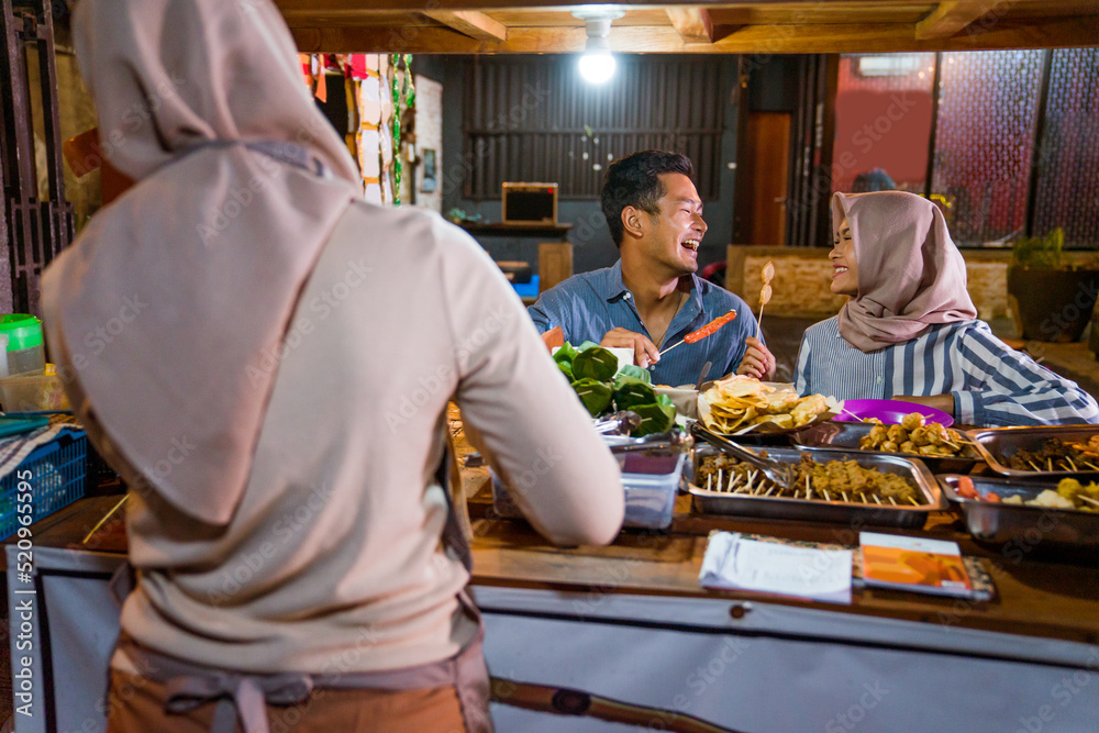 Muslim Couple Ordering Food To Break Fasting In Traditional Food Market