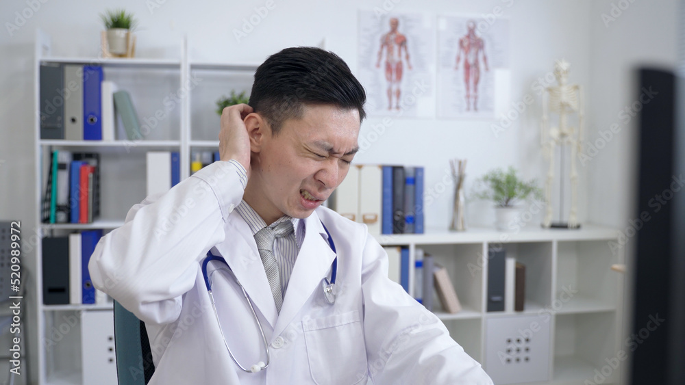 close up upset asian doctor looking at the monitor is scratching his ...