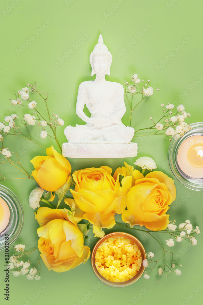 Buddha statue, yellow roses and candles on a green background. Magha ...