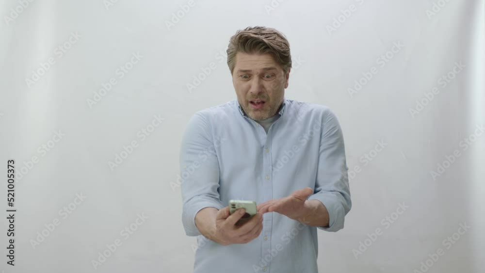 Unhappy angry man annoyed by what he sees on smartphone. Angry ...