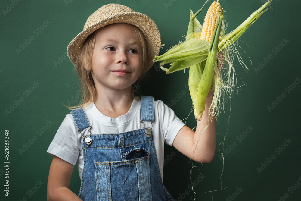 Cute caucasian little girl smiling while holding ear of corn on the ...