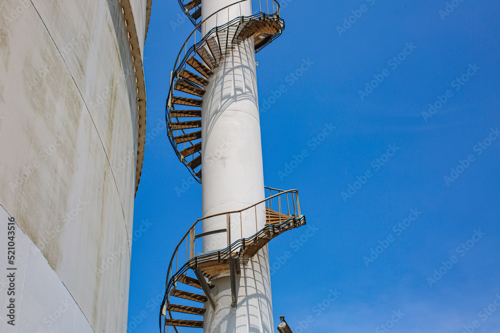 Curved stairway of base oil storage tank in the petroleum factory with ...