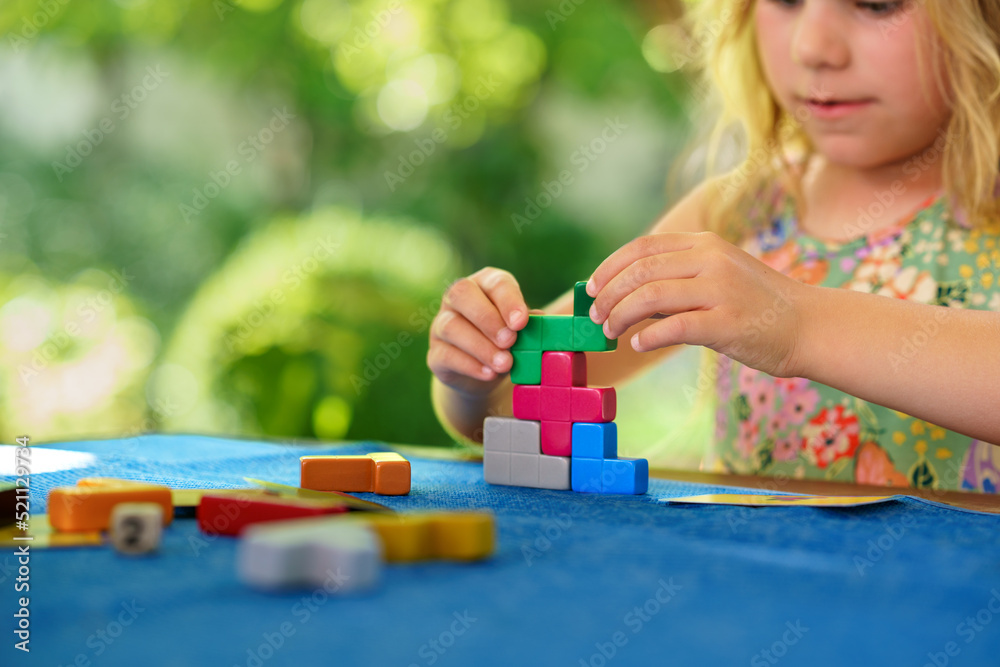 Little preschool girl playing board game with colorful bricks. Happy ...
