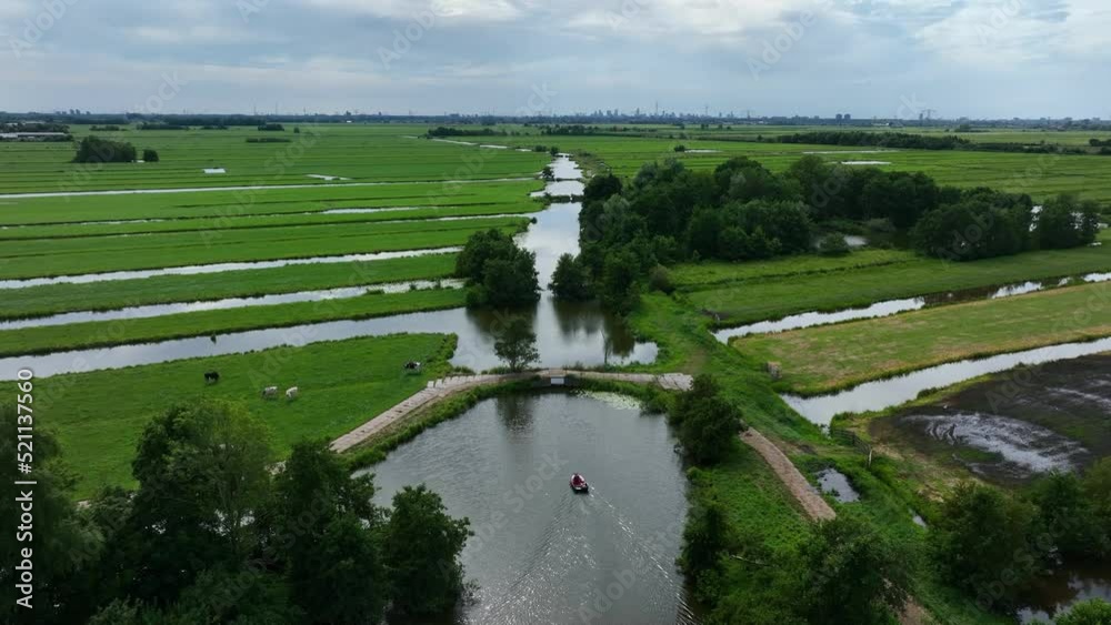 Motorboat on river through wet lush Krimpenerwaard polder farmland ...