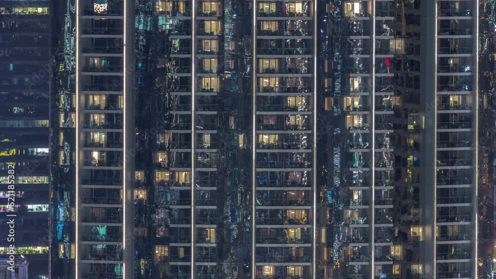 Windows lights in modern tower buildings timelapse at night. Multi ...