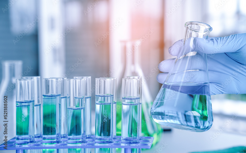 Hand of scientist with test tube and flask in medical chemistry lab ...
