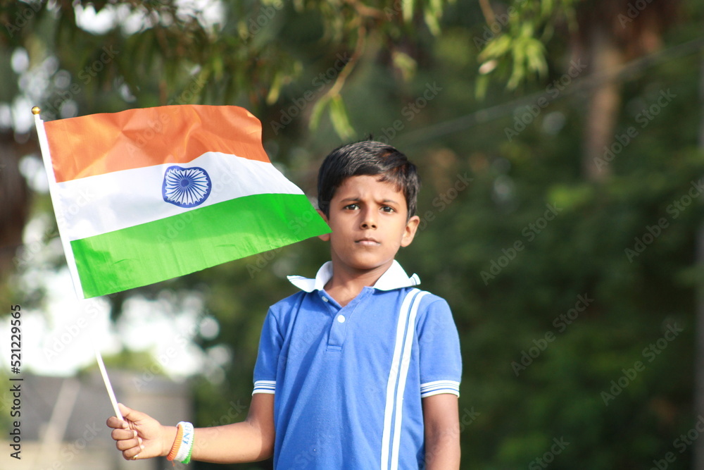 little indian boy proudly holding Indian National flag. The national ...