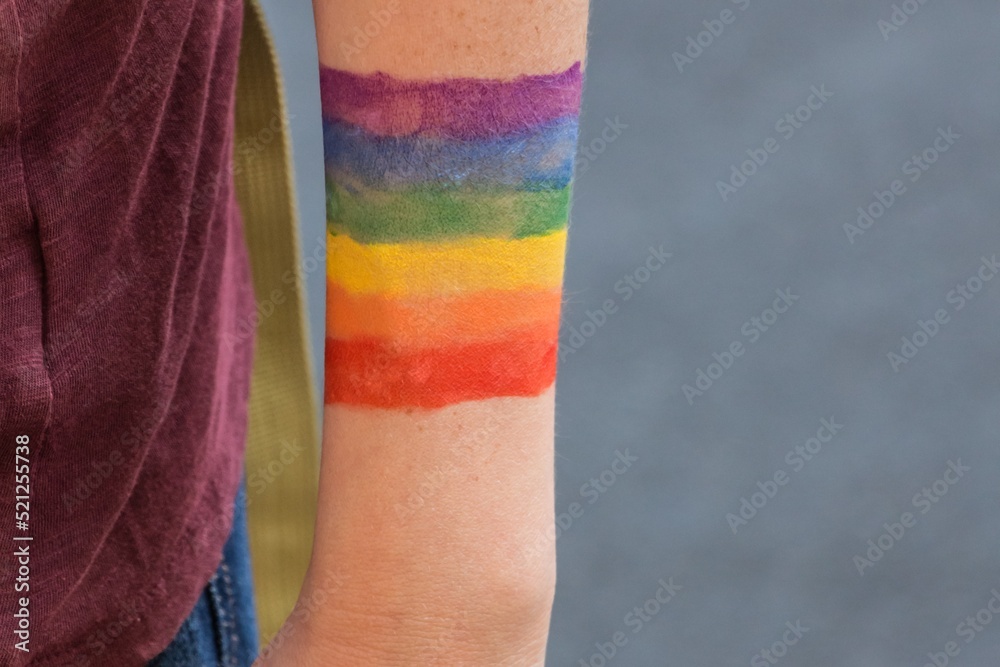 LGBTQ community colorful rainbow flag symbol painted at arm. Colors are ...
