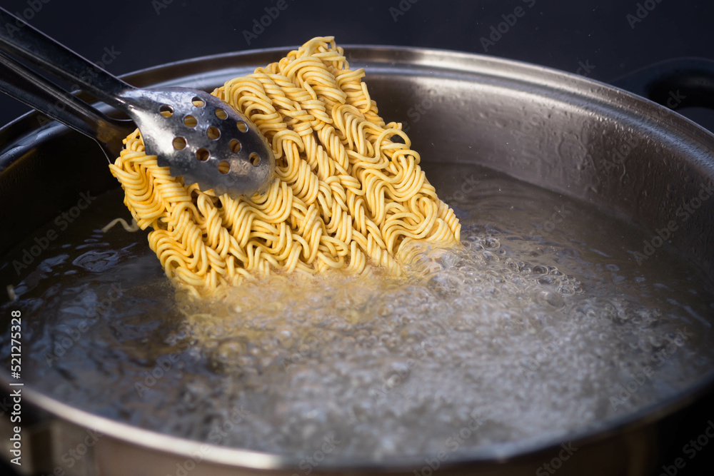 Boil instant noodles in boiling water in a country kitchen. Stock Photo ...