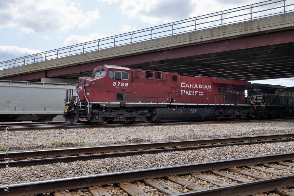 Foto de Locomotives sit under a highway overpass while leading a ...