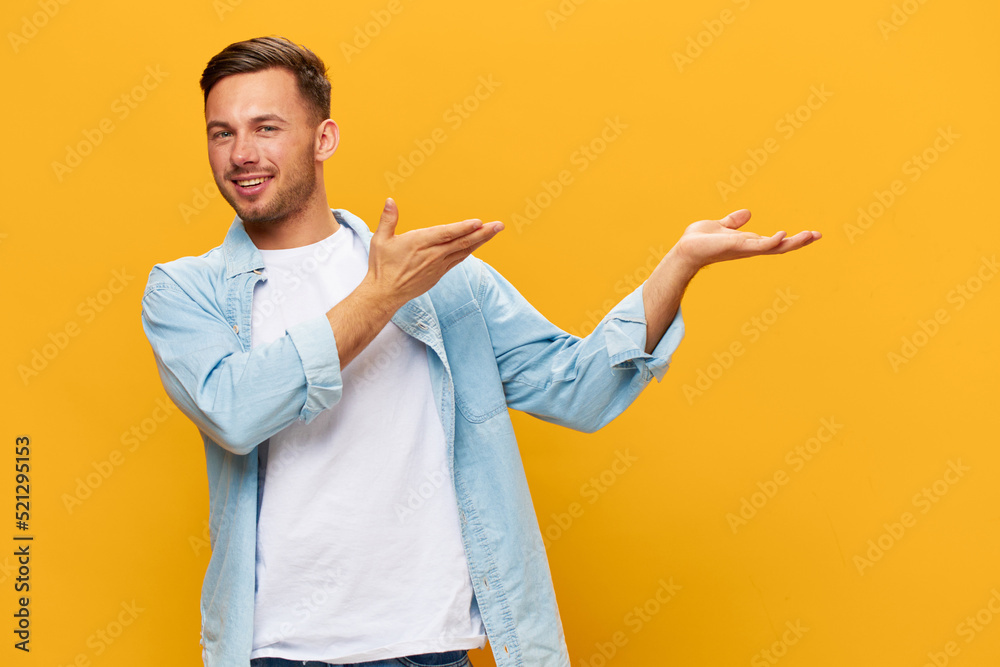 Smiling happy tanned handsome man in blue basic t-shirt hold invisible ...