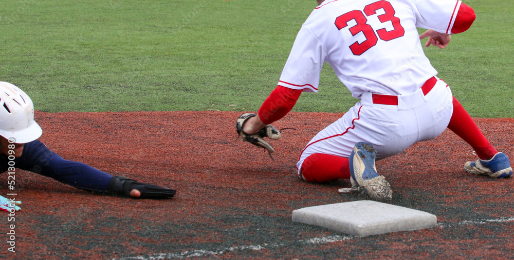 Basebal player head first sliding into third wearing sliding gloves ...