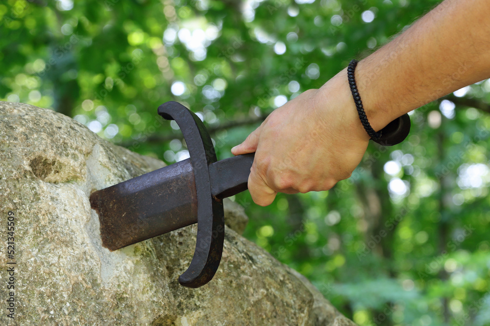 hand and sword in the stone as in the legend of King Arthur Stock Photo ...