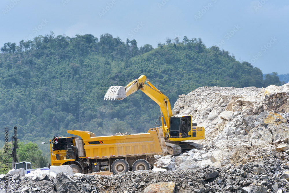 Excavator dig ground at construction site. Earthmover on road ...