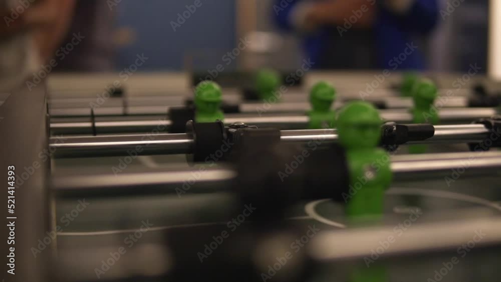 A close up shot of table soccer which is being played by group of young ...