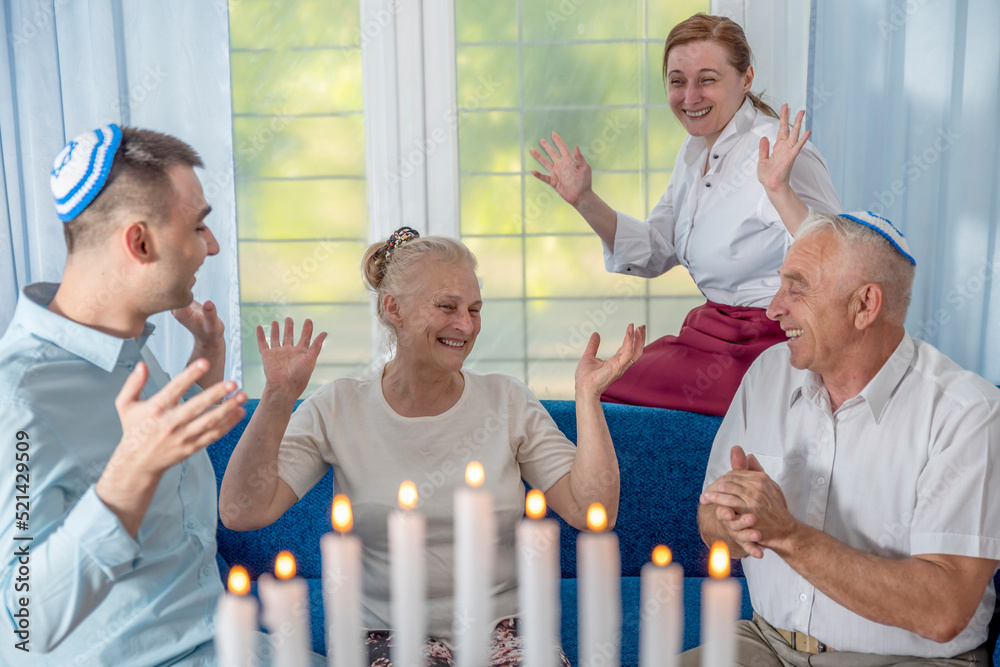 Jewish family celebrates Hanukkah. A senior man and young guy wear ...