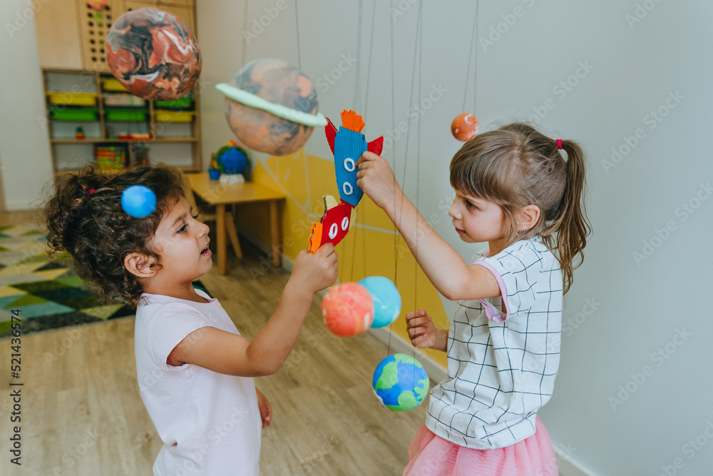 Little girl playing with paper spaceship learning Solar system planets ...