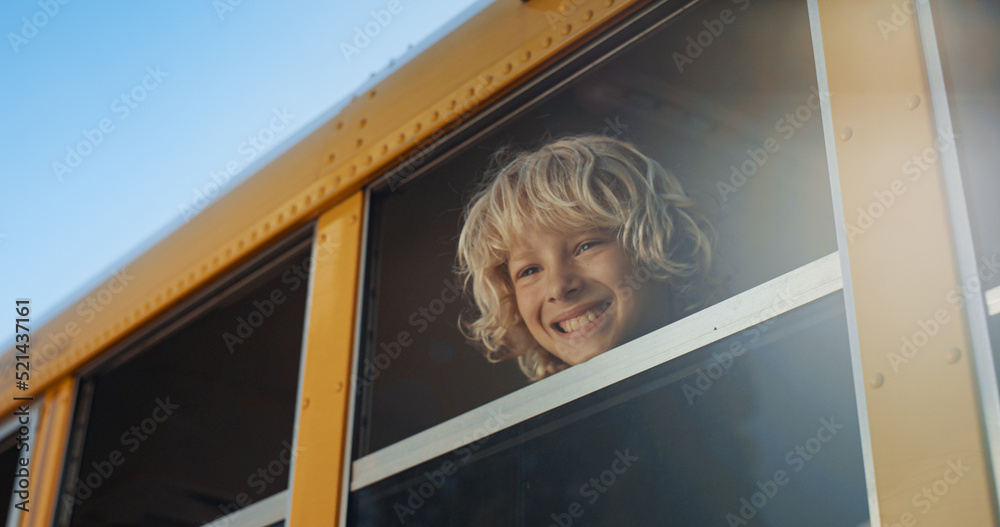 Smiling boy looking out school bus window close up. Student standing in ...