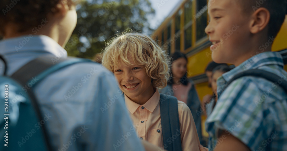 Preteen schoolboys stand laughing at bus. Boys wait for schoolbus ...