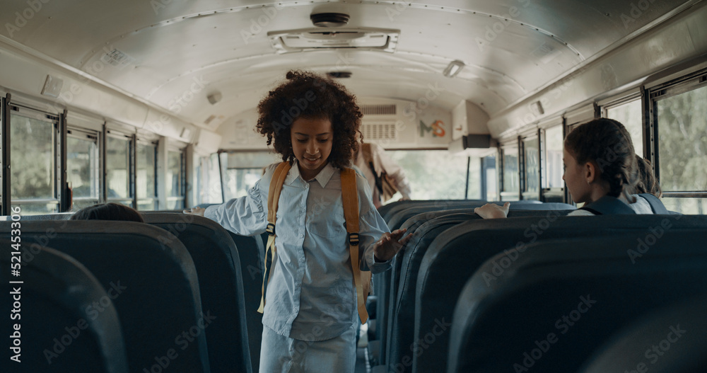School children boarding schoolbus. Diverse students getting in ...