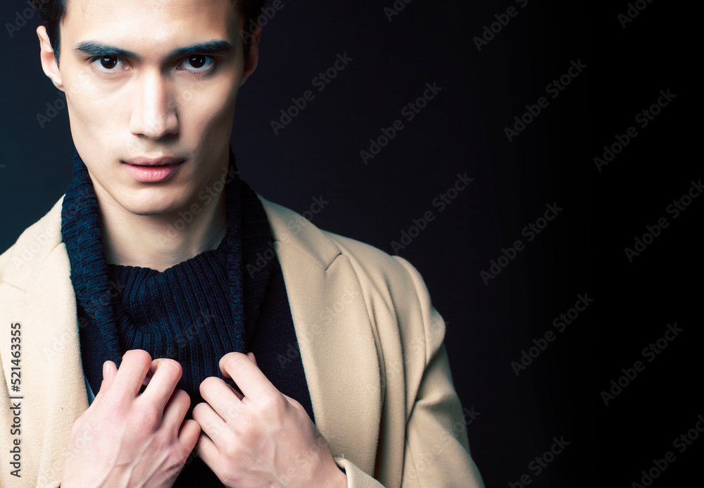 handsome asian fashion looking man posing in studio on black background ...