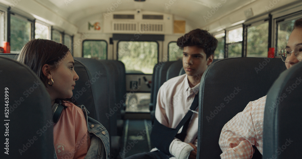Three teenagers sitting school bus talking alone. Smiling girl taking ...