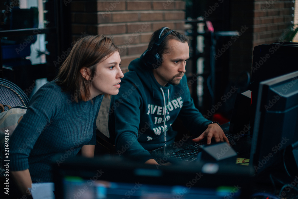 Editing director behind monitors on the set. A video editor edits video ...