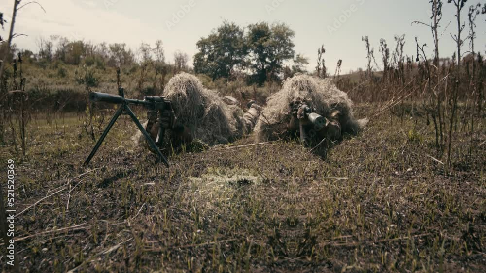 Snipers in an ambush in the grass, disguised as terrain on an anti ...