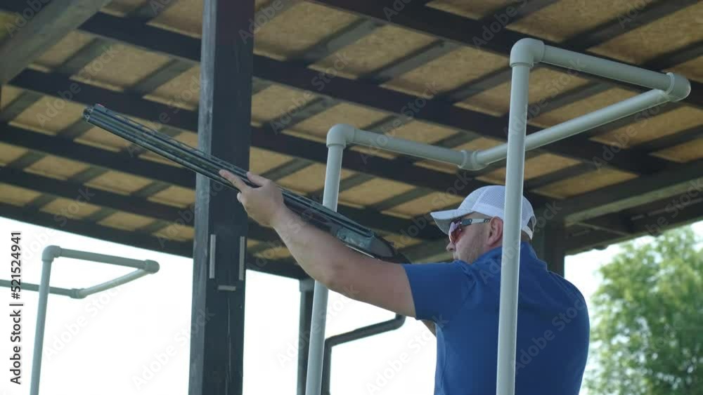 Sportsman shoots from a double-barreled shotgun, A sports field for a ...