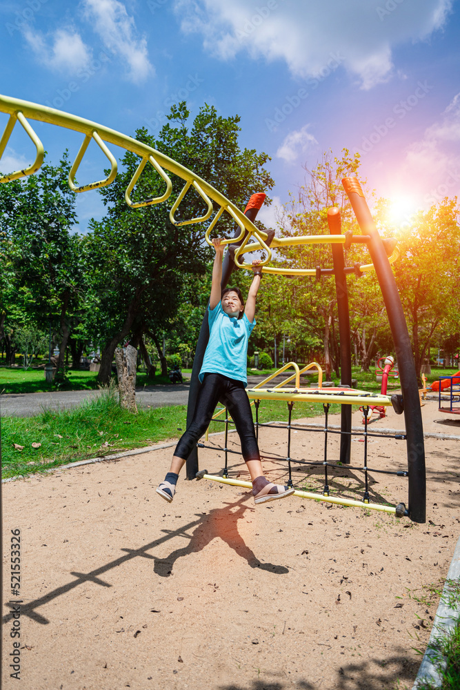 Cute child girl hanging hanging on monkey bars at the playground in ...