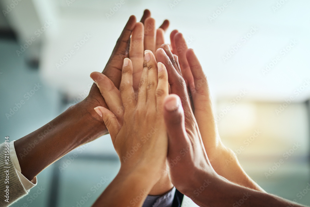 Hands, huddle and high five while a group of diverse businesspeople celebrate and motivate each ...