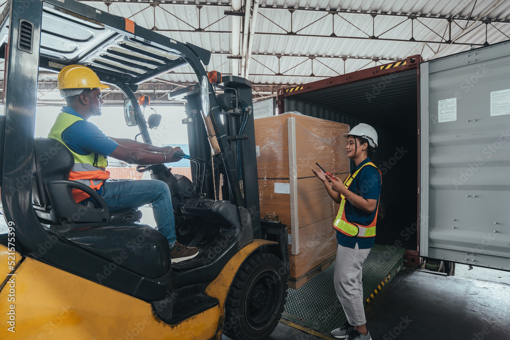 Forklift driver loading a shipping cargo container in Logistic center ...