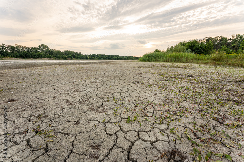 Drought and climate change, landscape of cracked earth with orange sky ...