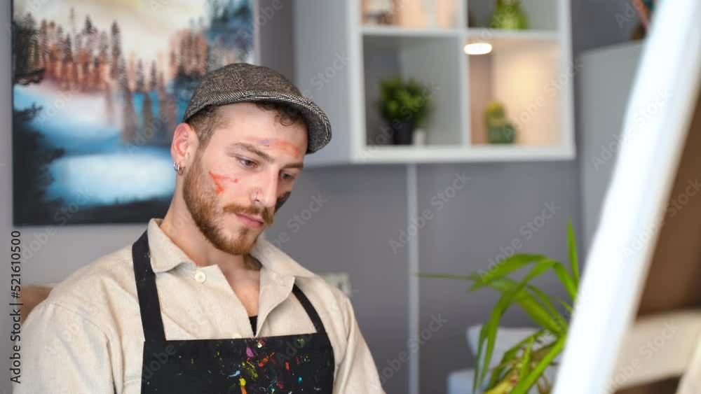 Painter's face while painting. While painting, the painter wipes his ...