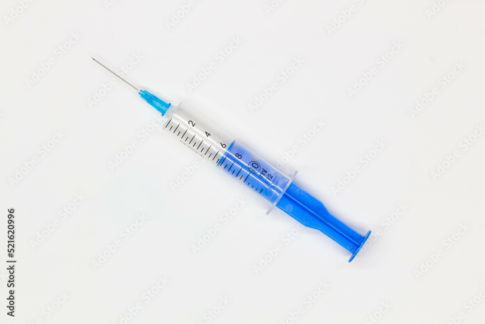 Blue medical disposable syringe for injection on a white background ...