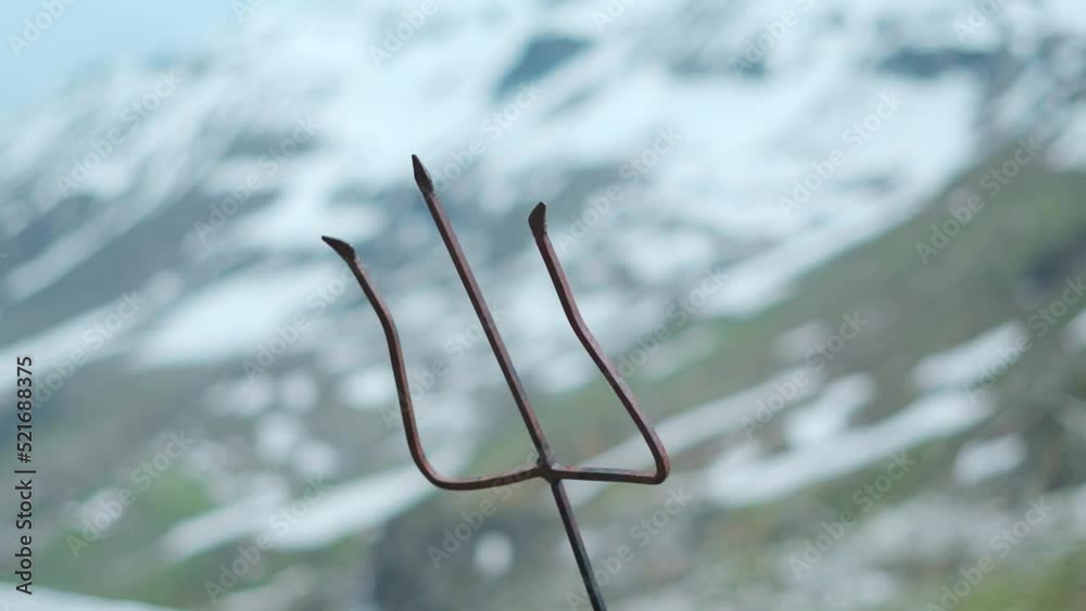 Close up shot of Shiva Trishul in background of snow Himalayan mountain ...