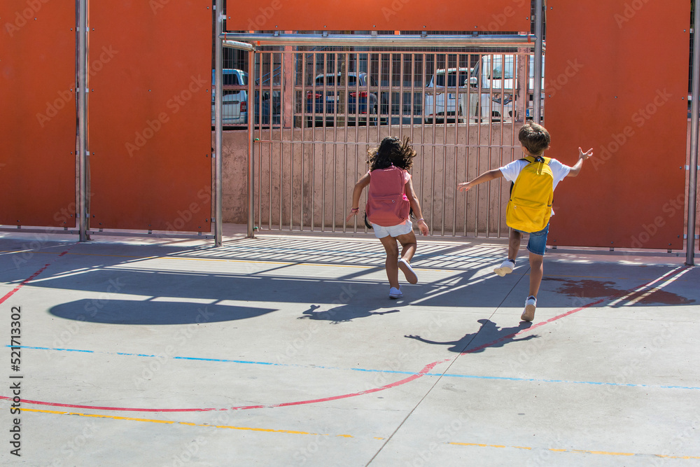 Elementary age children playing in the schoolyard. Girl and boy with ...