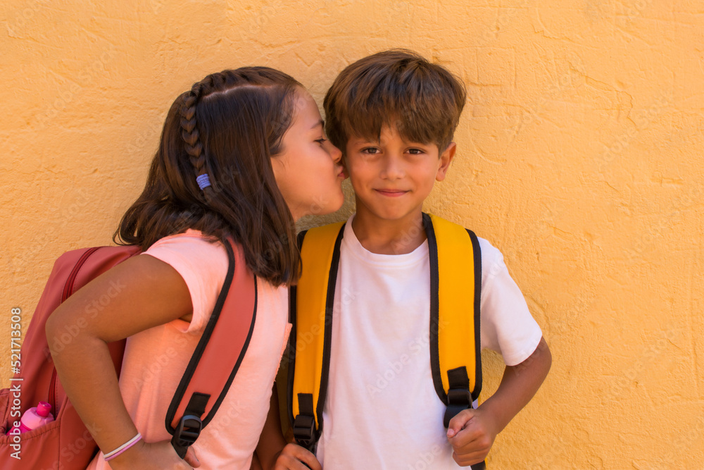 School girl kissing her brother. School boys on yellow background Stock ...