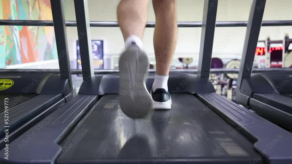 Sport and fitness concept. Young man walking and running on a treadmill ...