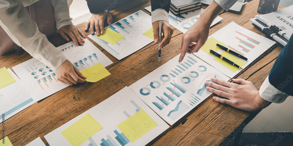 Teamwork with business people analysis cost graph on the desk in the ...