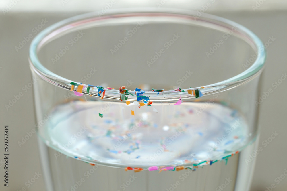 Microplastics or tiny plastic particles in a glass of water.Drinking ...