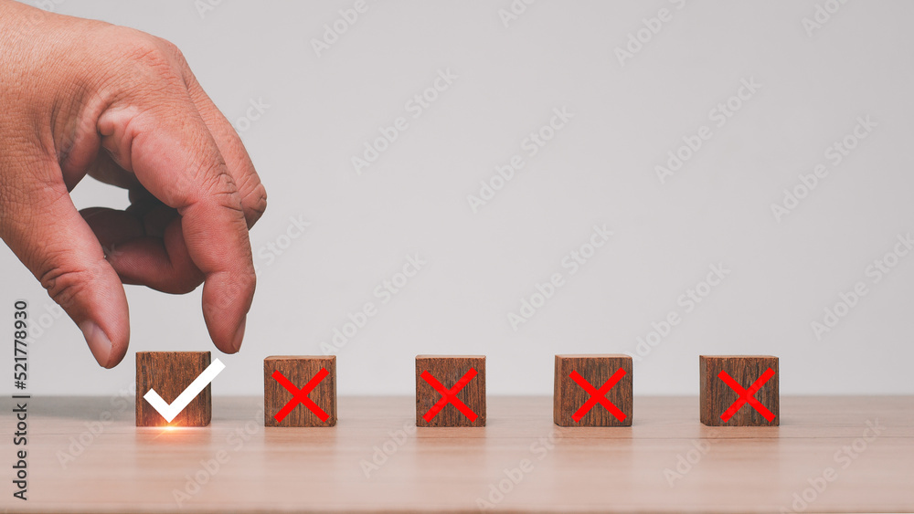Checklist concept. Hands are holding on. Check mark on wooden block ...