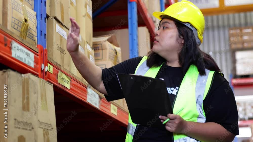 Asian obese female warehouse worker in safety vest and hardhat helmet ...