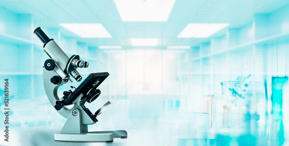 Microscope on the table with chemical tube and glassware in laboratory ...