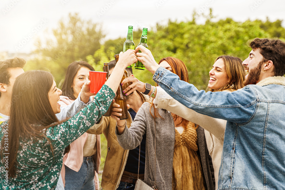 Cheerful friends gathering raising beers for a celebratory toast ...