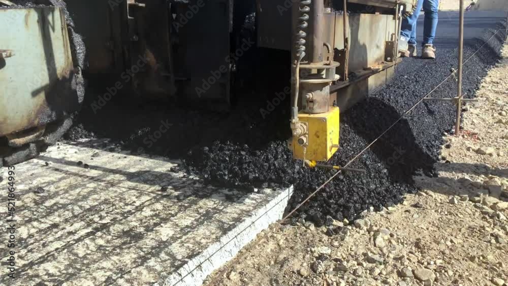 Asphalt paver lays asphalt mix on concrete foundation. Black top paver ...