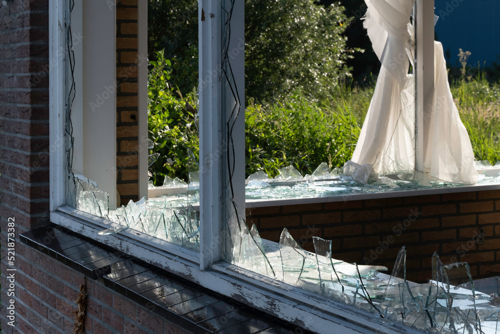 Broken glass windows, caused by vandalism or demolition, in a brick ...